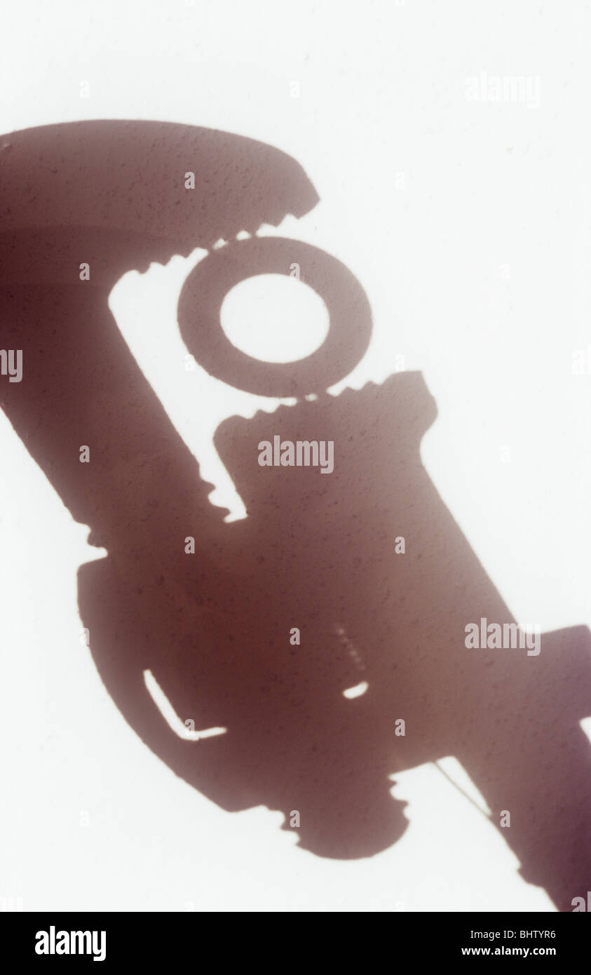 Shadow on white wall of adjustable spanner or self-grip wrench or vice ...