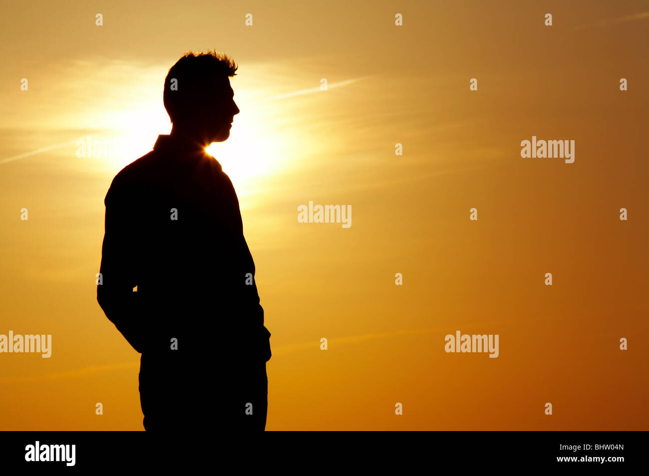 Silhouette of a young man at sunset Stock Photo - Alamy