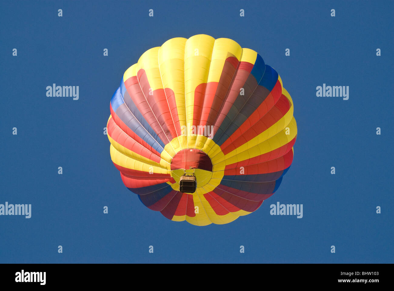 Big Hot air balloon flying up in a clear blue sky Stock Photo - Alamy