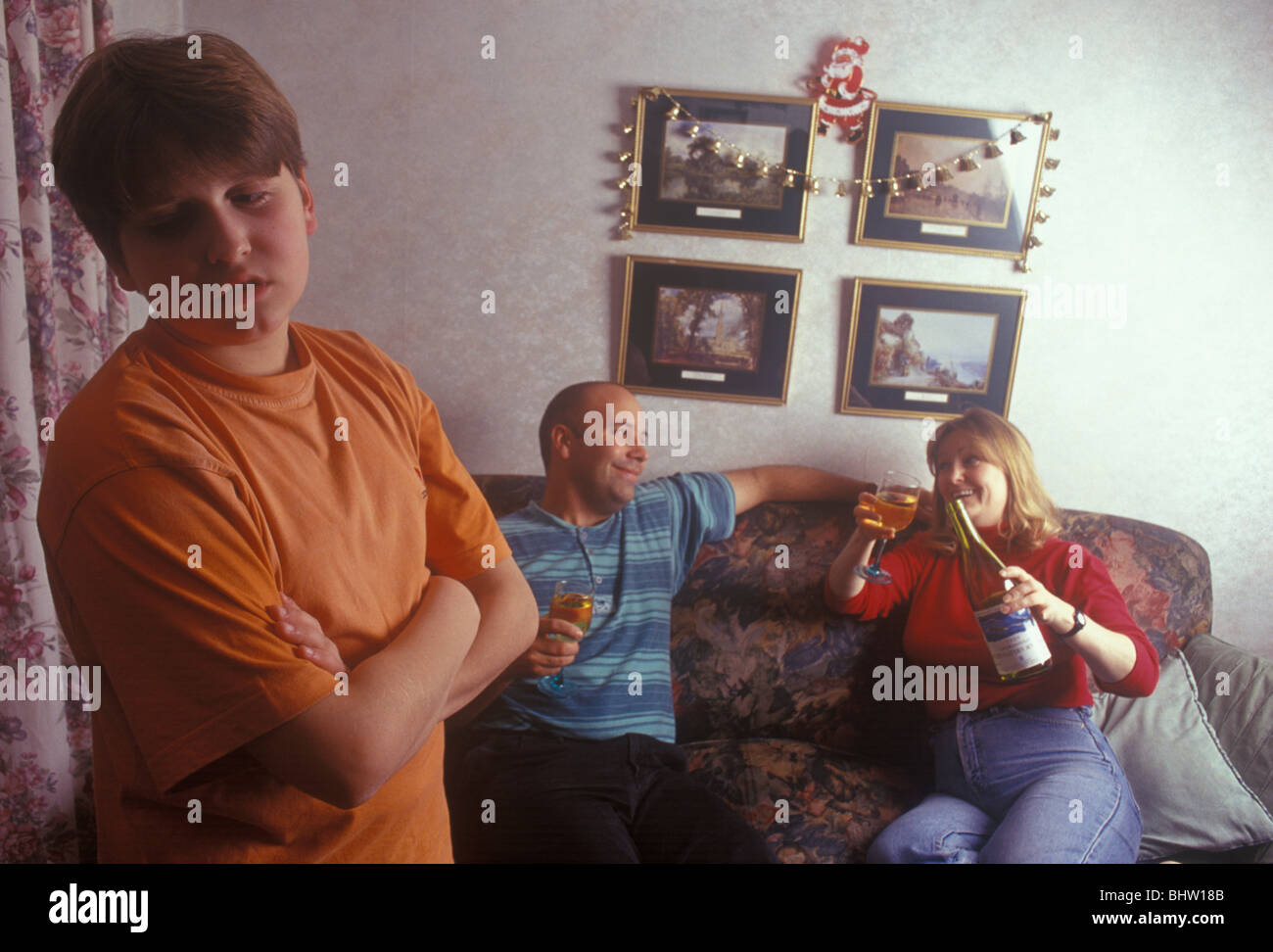 boy looking fed up as his parents get drunk Stock Photo - Alamy