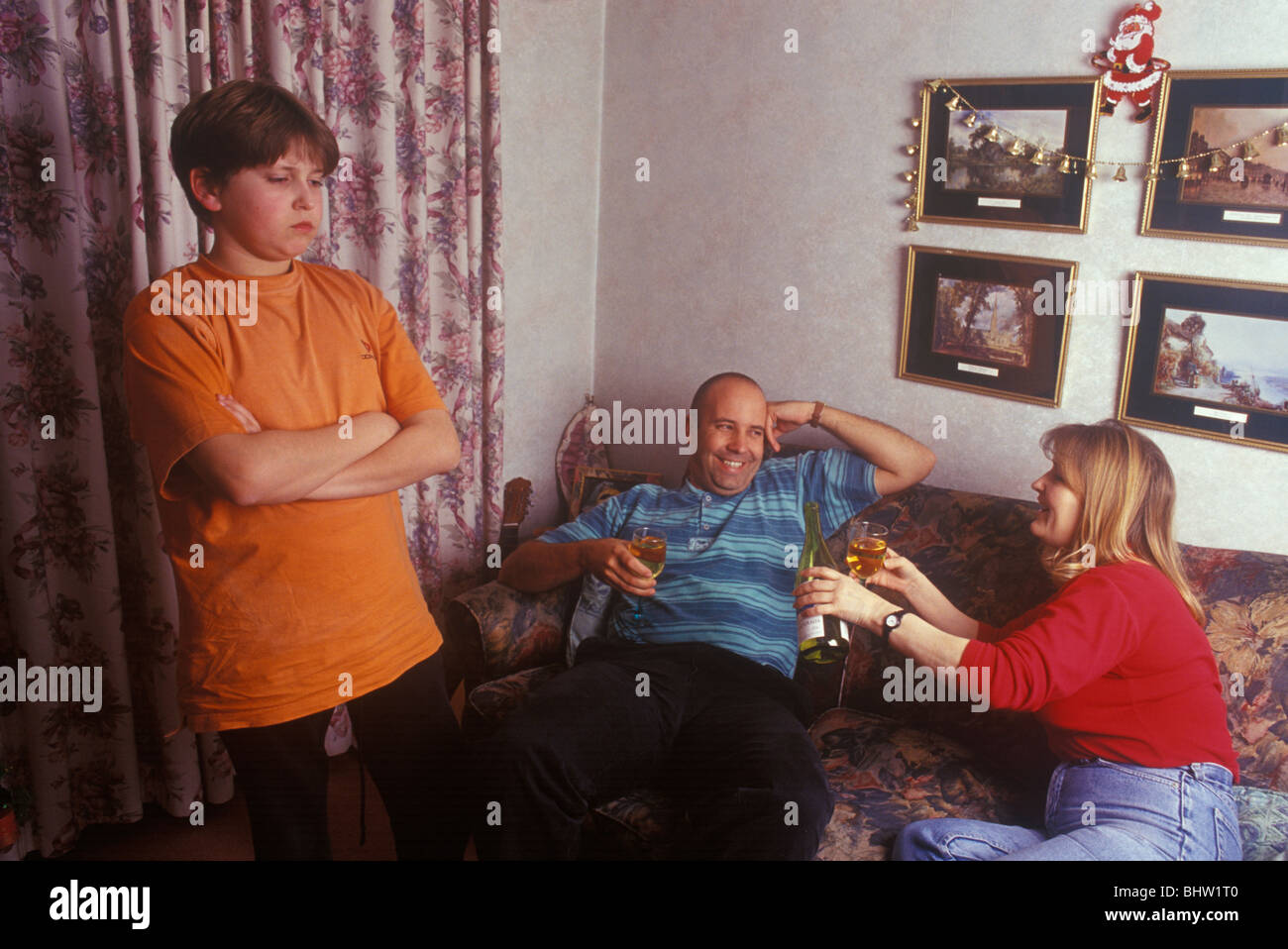 boy looking fed up as his parents get drunk Stock Photo - Alamy