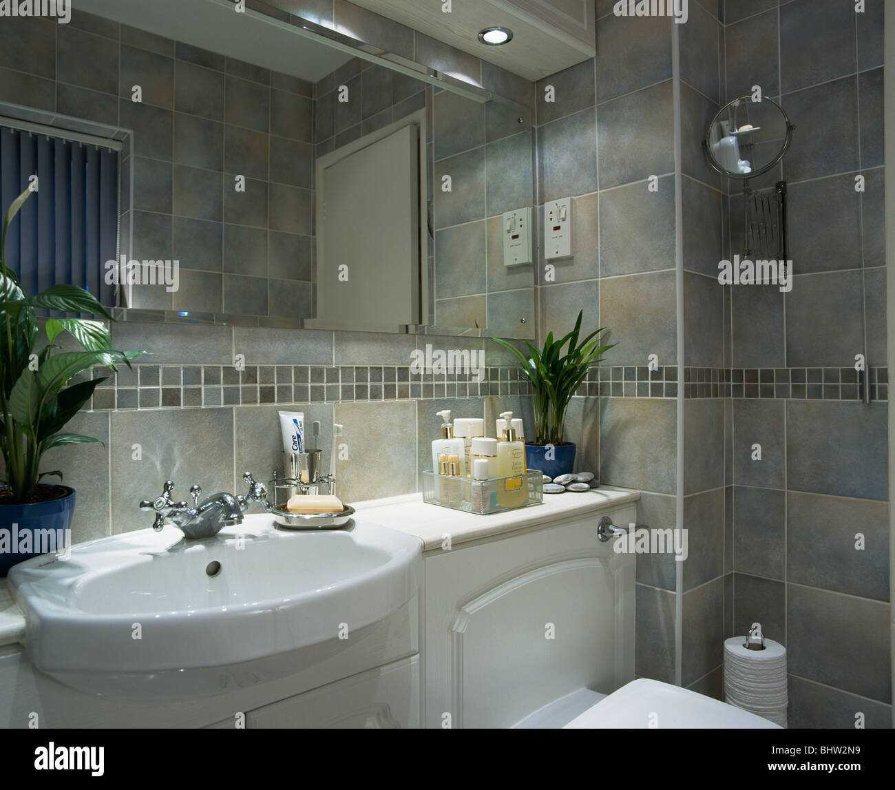 White basin in vanity unit in modern gray tiled bathroom Stock Photo ...