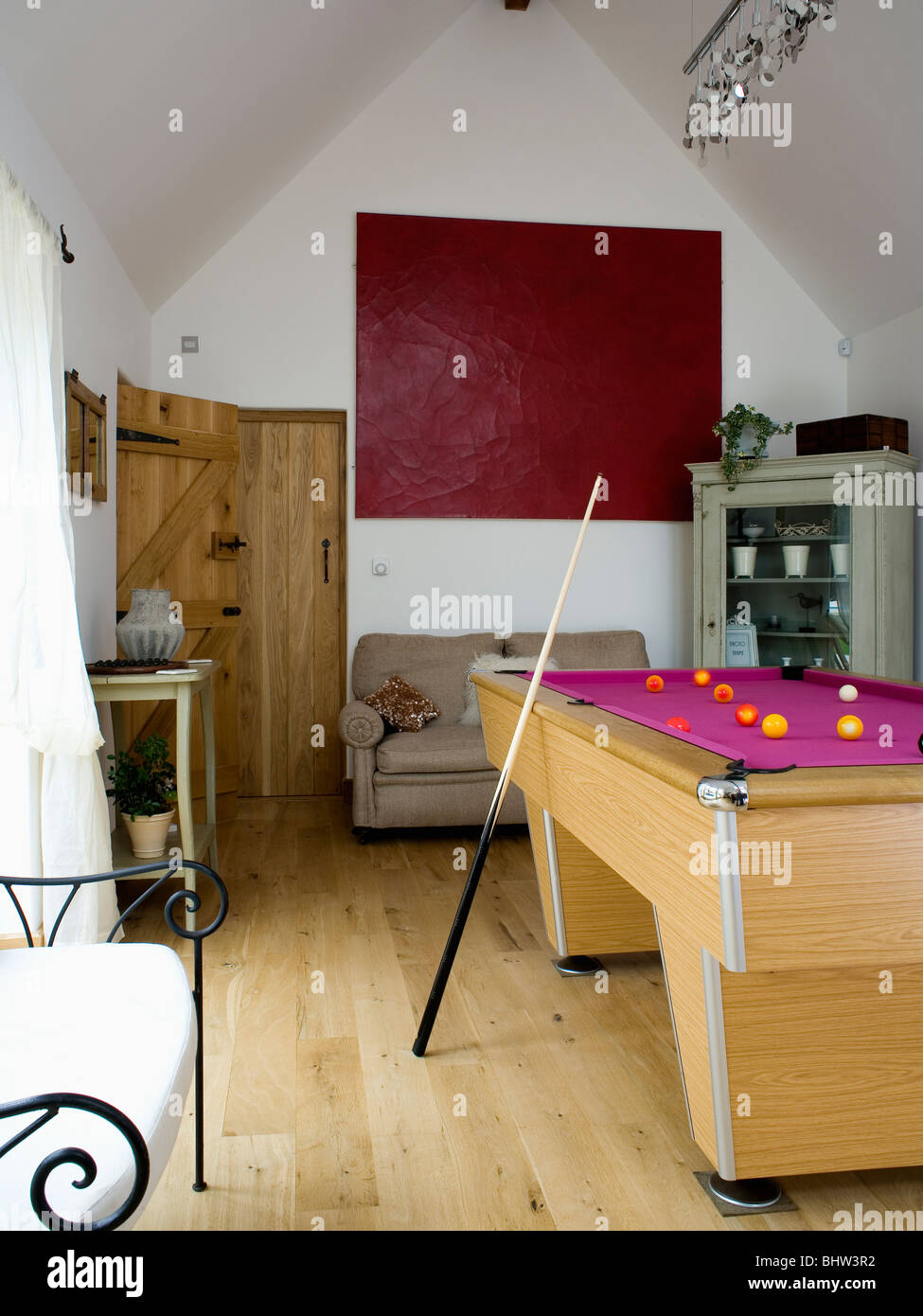 Pool table and cue in games room with wooden flooring Stock Photo - Alamy