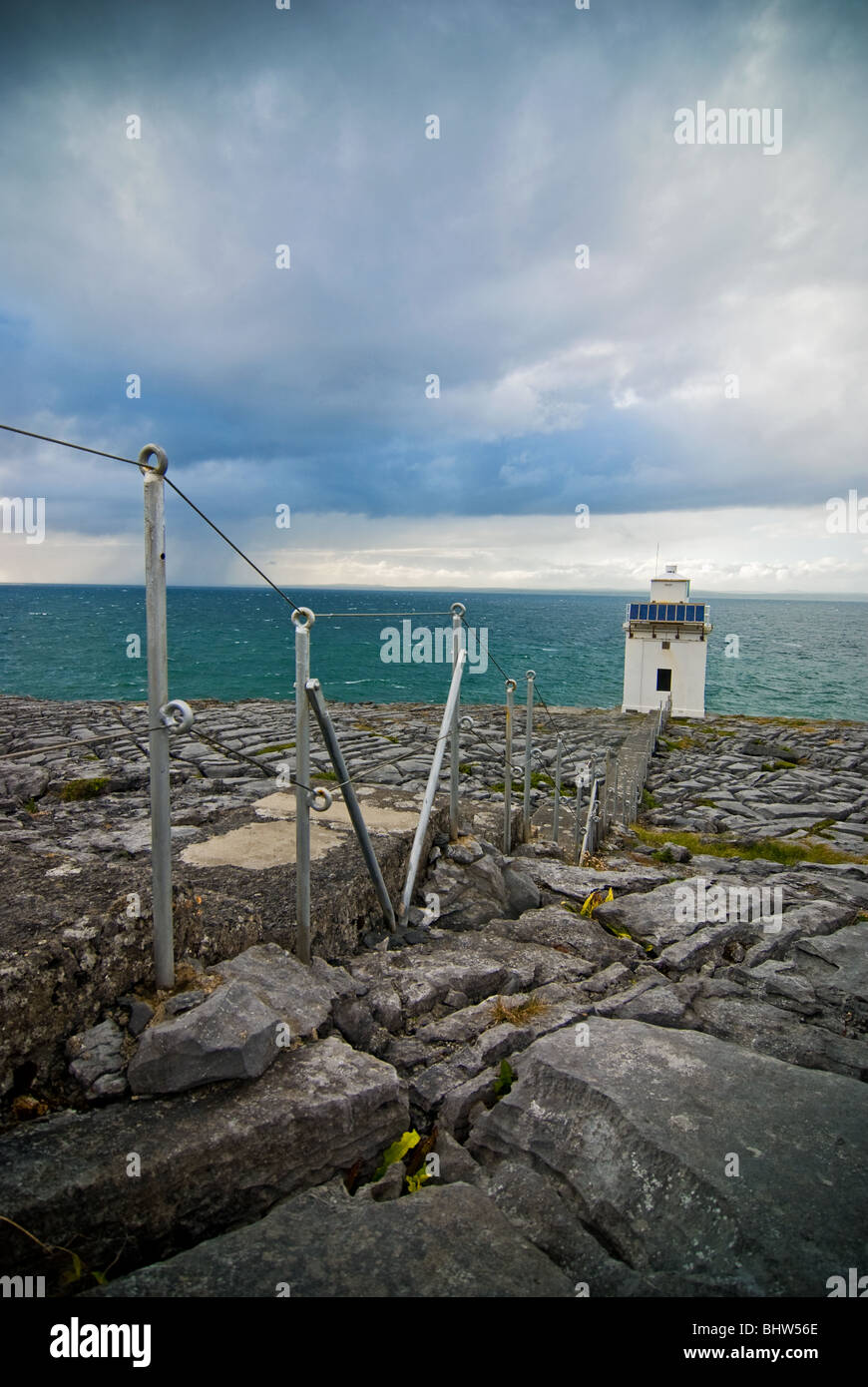 The Black Head lighthouse with distant storms over the Atlantic Ocean ...