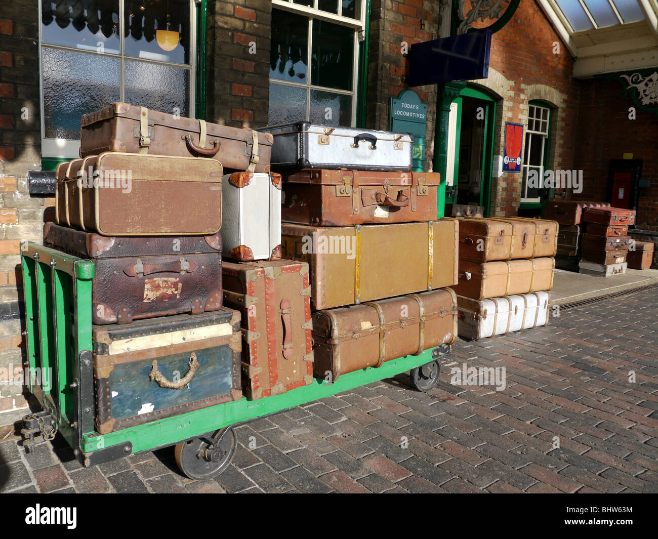Old fashioned suit cases stacked onto a baggage trolley at a railway ...