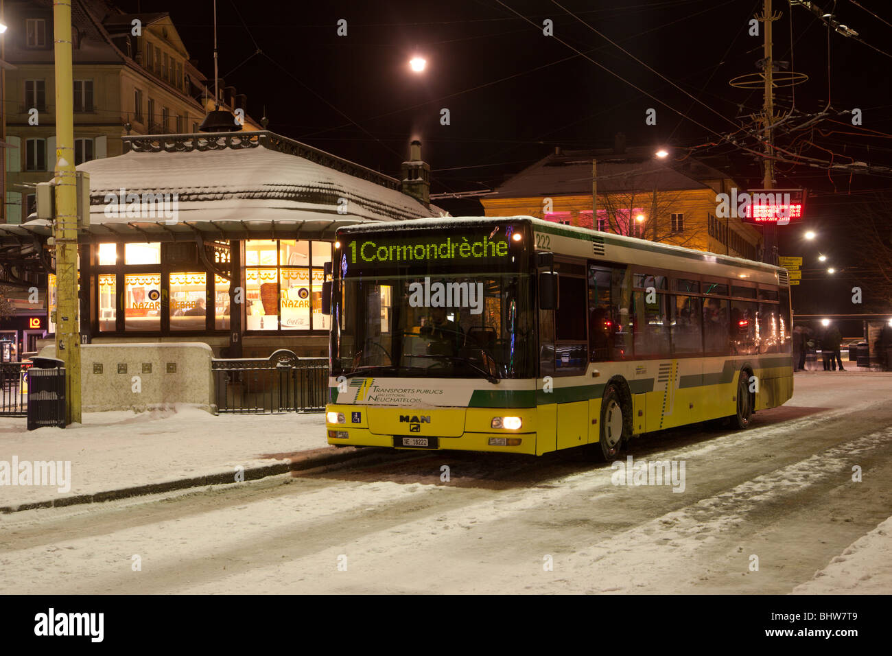 Nighttime view of a city bus at the bus stop on Place Pury, Neuchatel ...