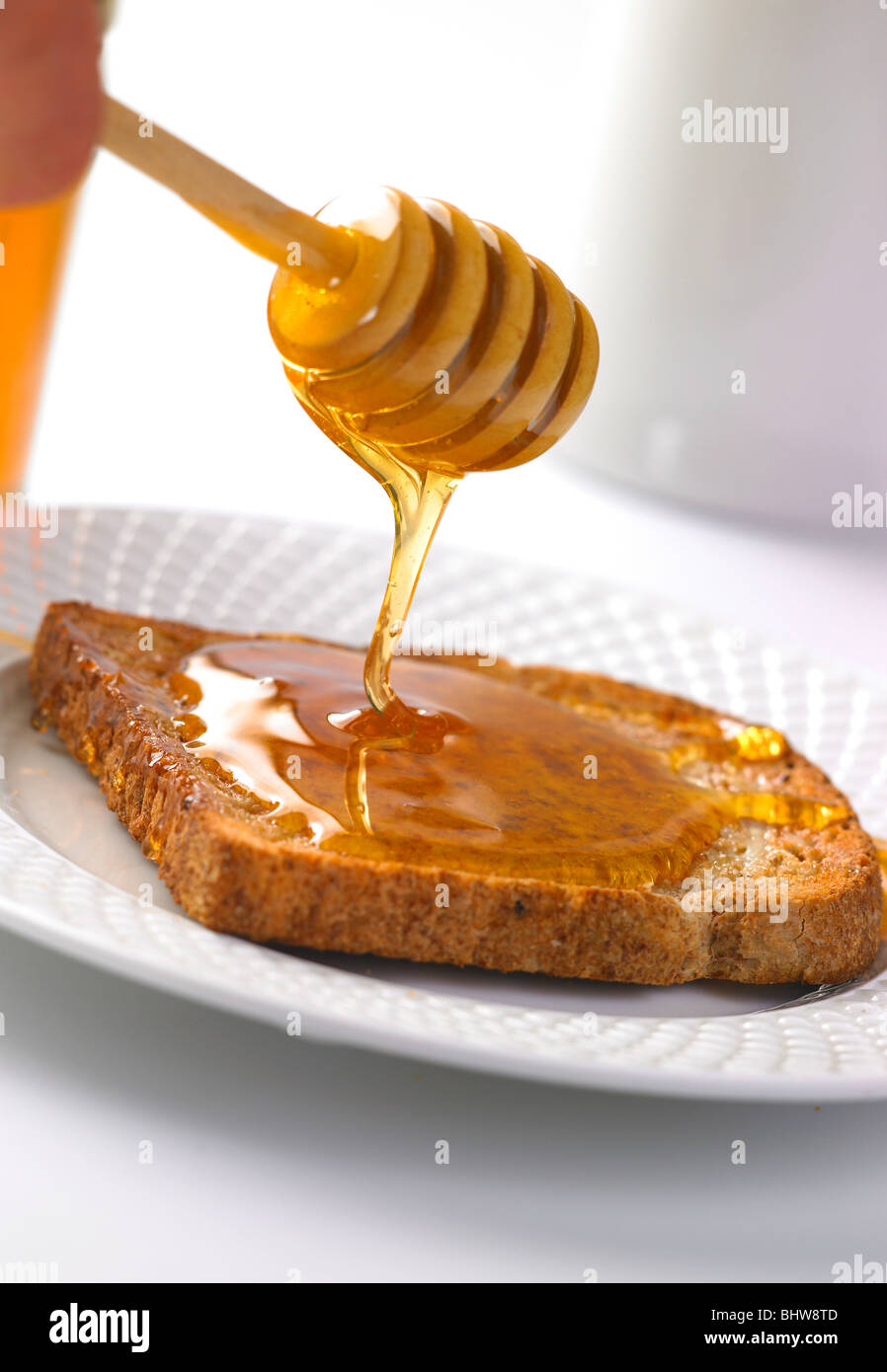 honey stick dripping honey onto toast Stock Photo - Alamy
