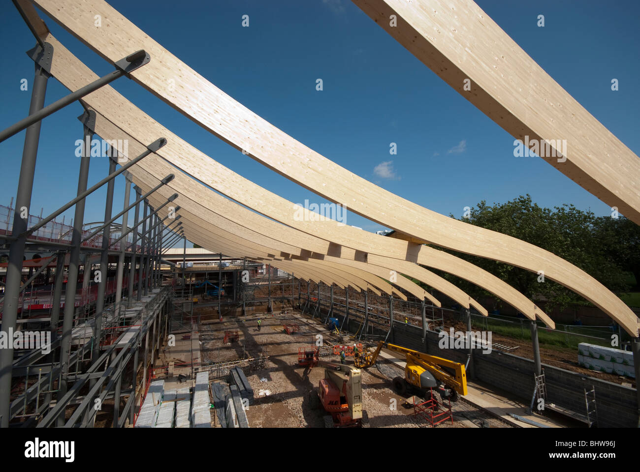 High level Construction workers building laminated wood wave roof on ...