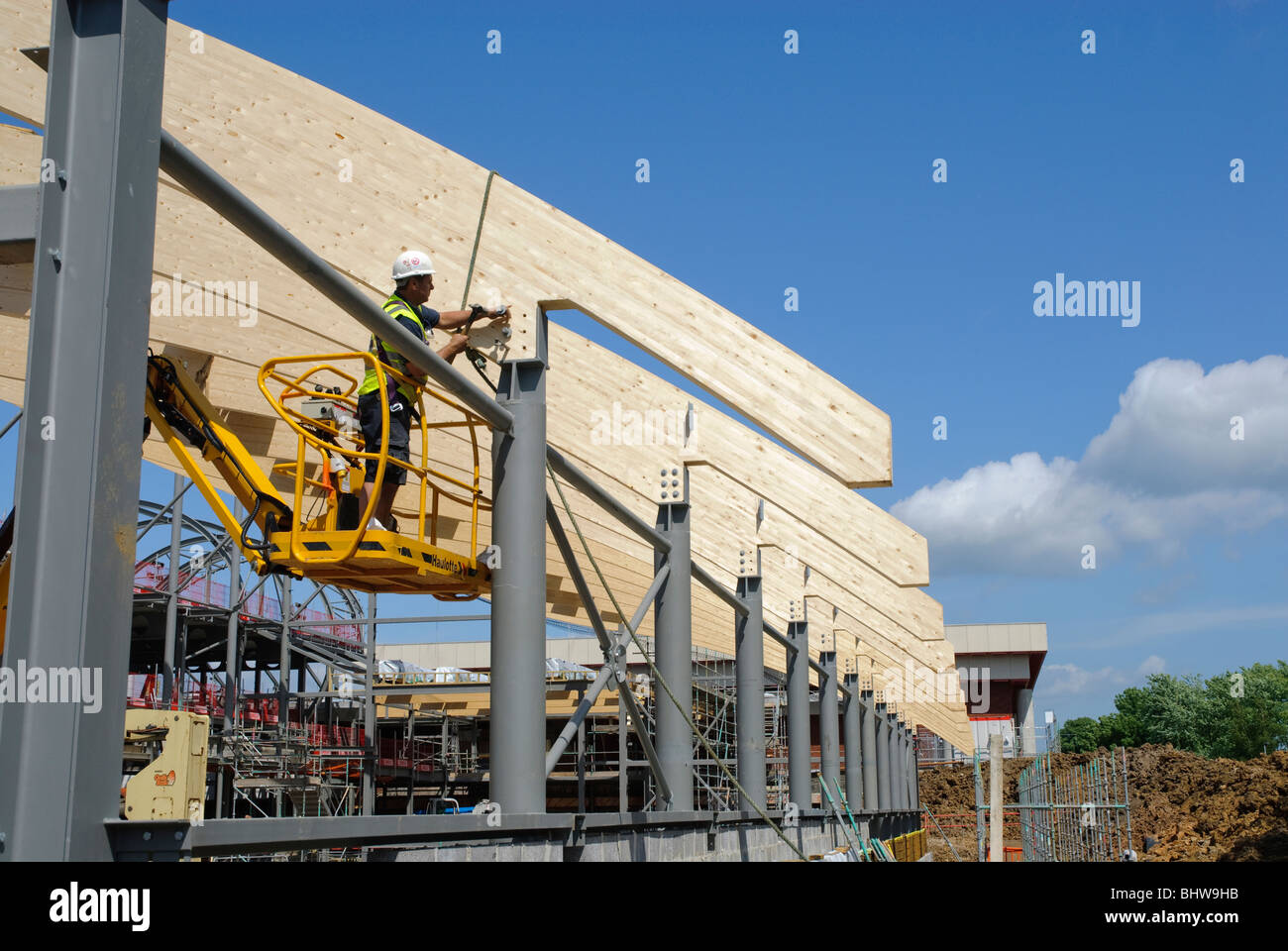 High level Construction workers building laminated wood wave roof on ...