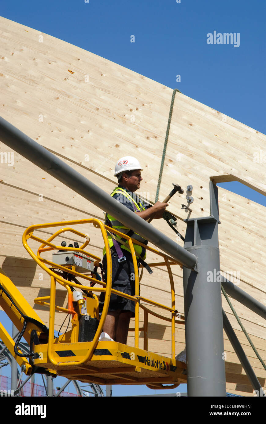 High level Construction workers building laminated wood wave roof on ...