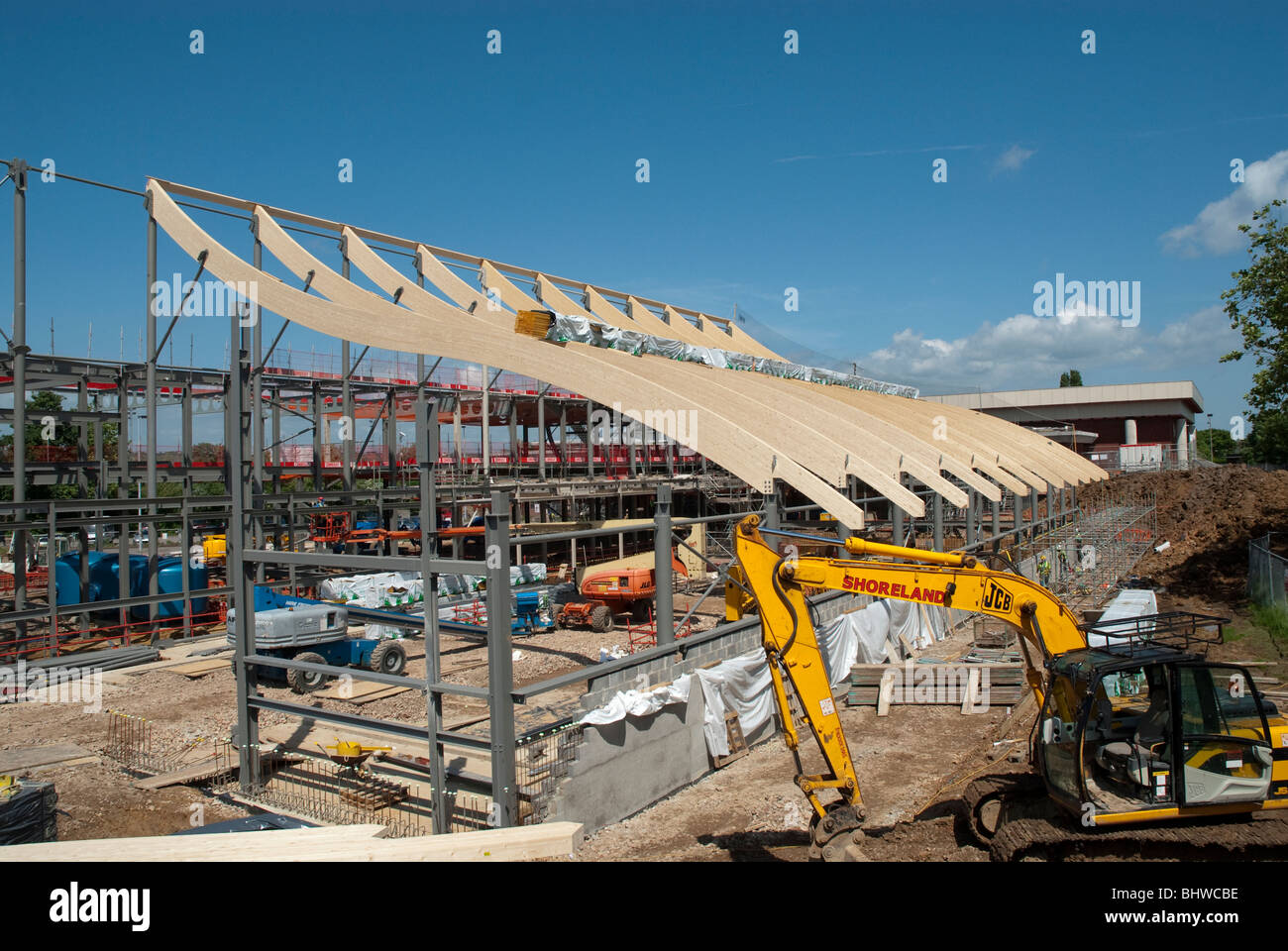 High level Construction workers building laminated wood wave roof on ...