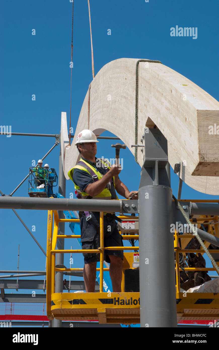 High level Construction workers building laminated wood wave roof on ...