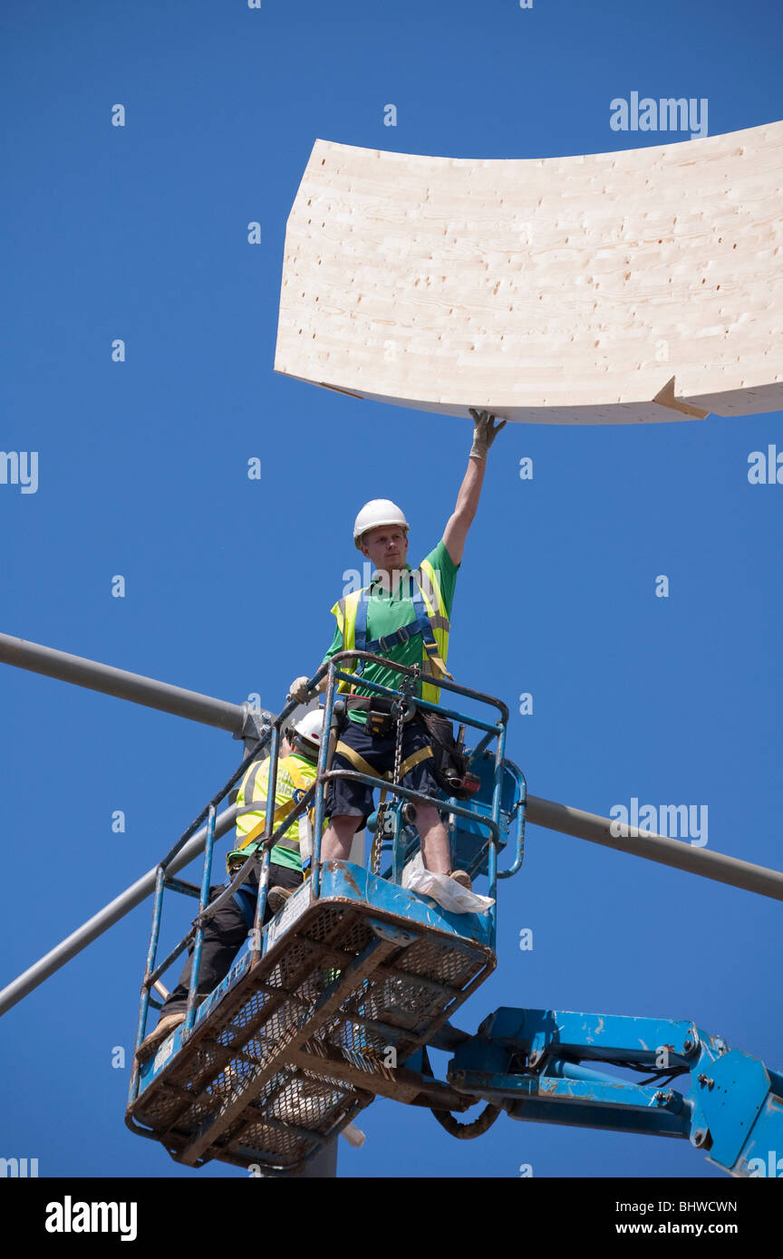 High level Construction workers building laminated wood wave roof on ...