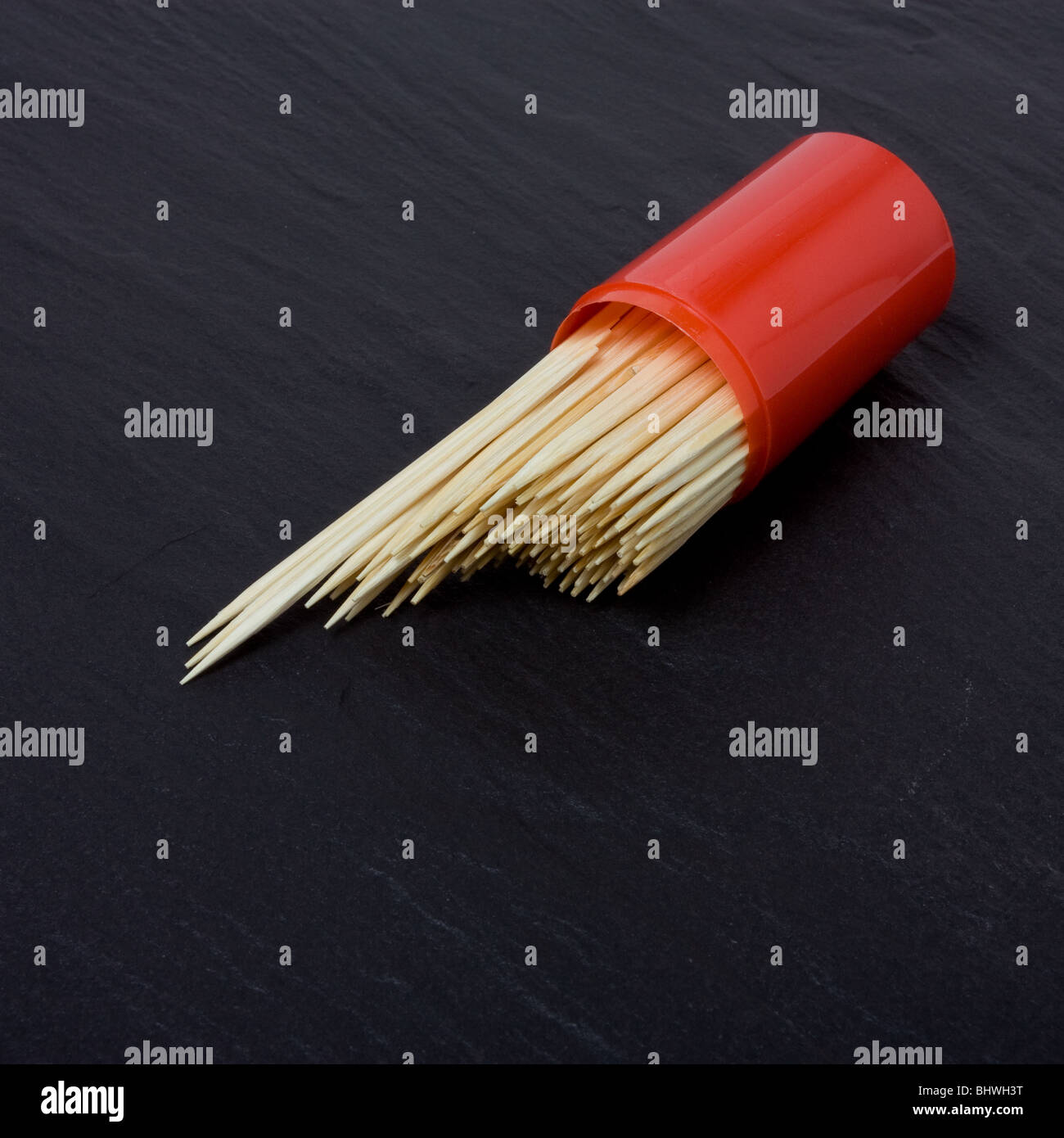 Cocktail Sticks spilling from container on dark slate background Stock ...