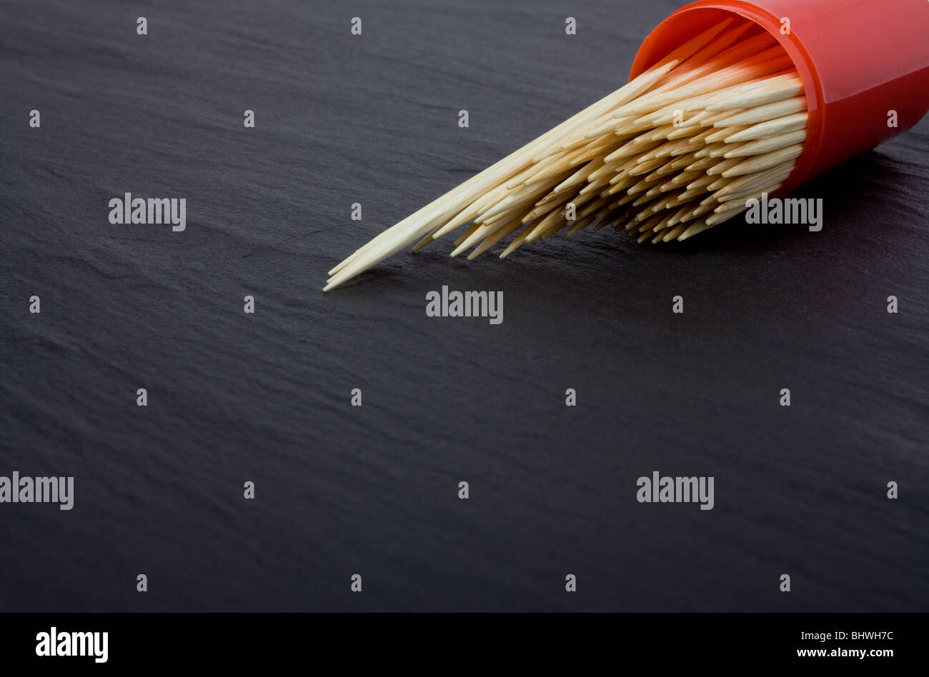 Cocktail Sticks spilling from container on dark slate background Stock ...