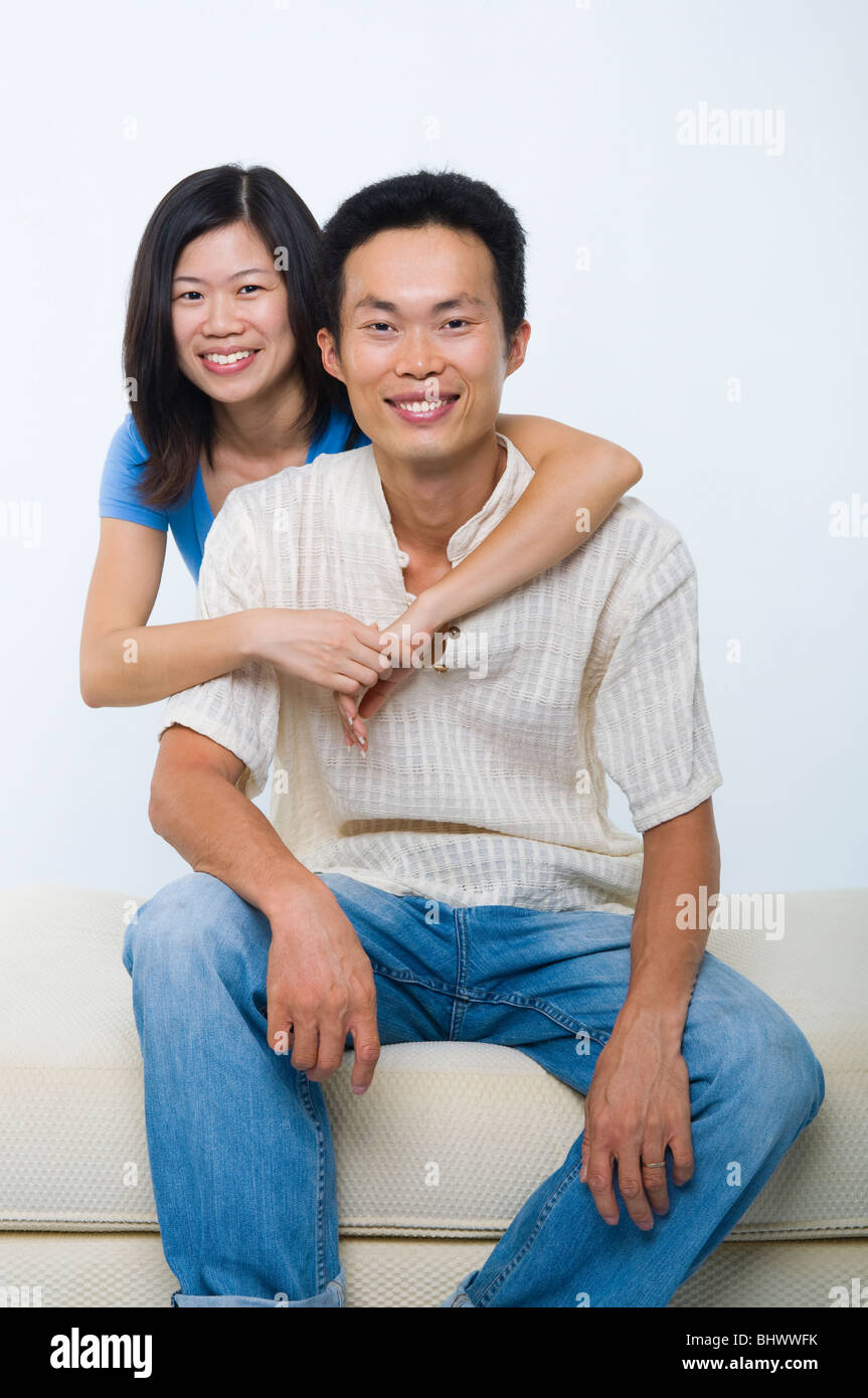 Young Asian couple sitting on sofa with smiling face, on white ...