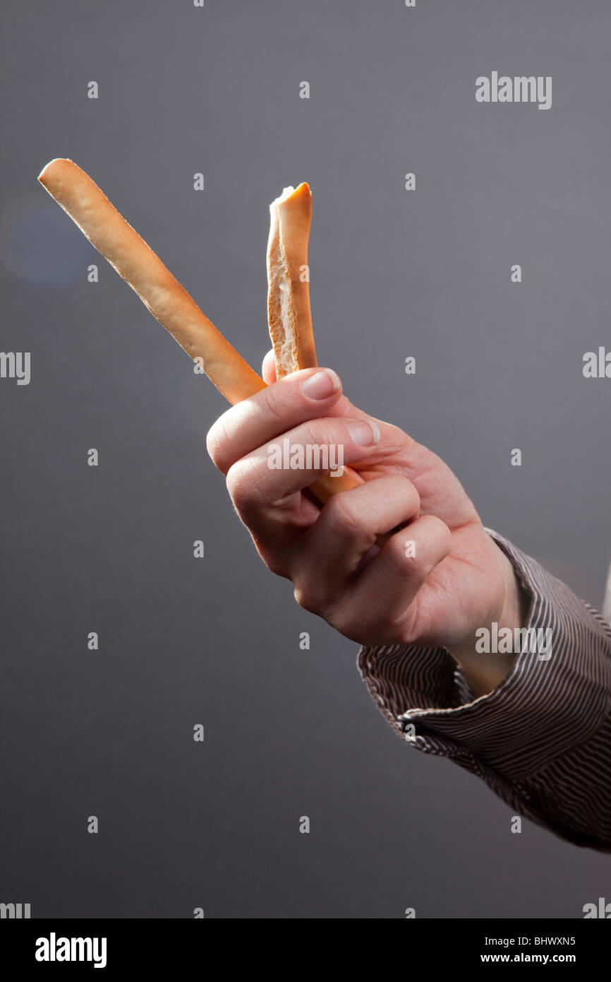 Female hand holding two breadsticks Stock Photo - Alamy