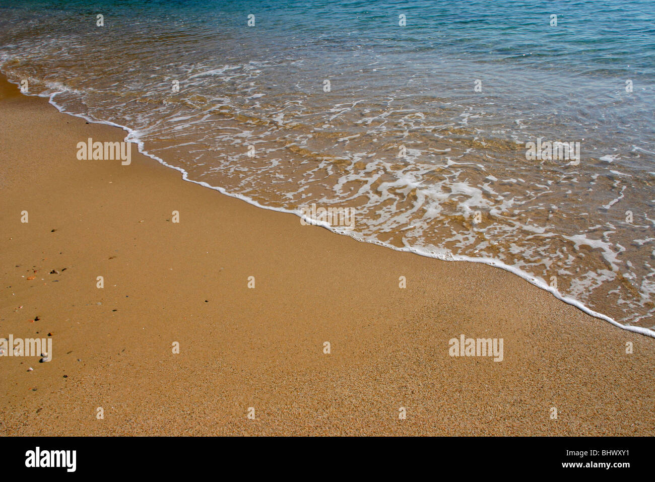 Water rolling gently onto a beach in Spain Stock Photo - Alamy