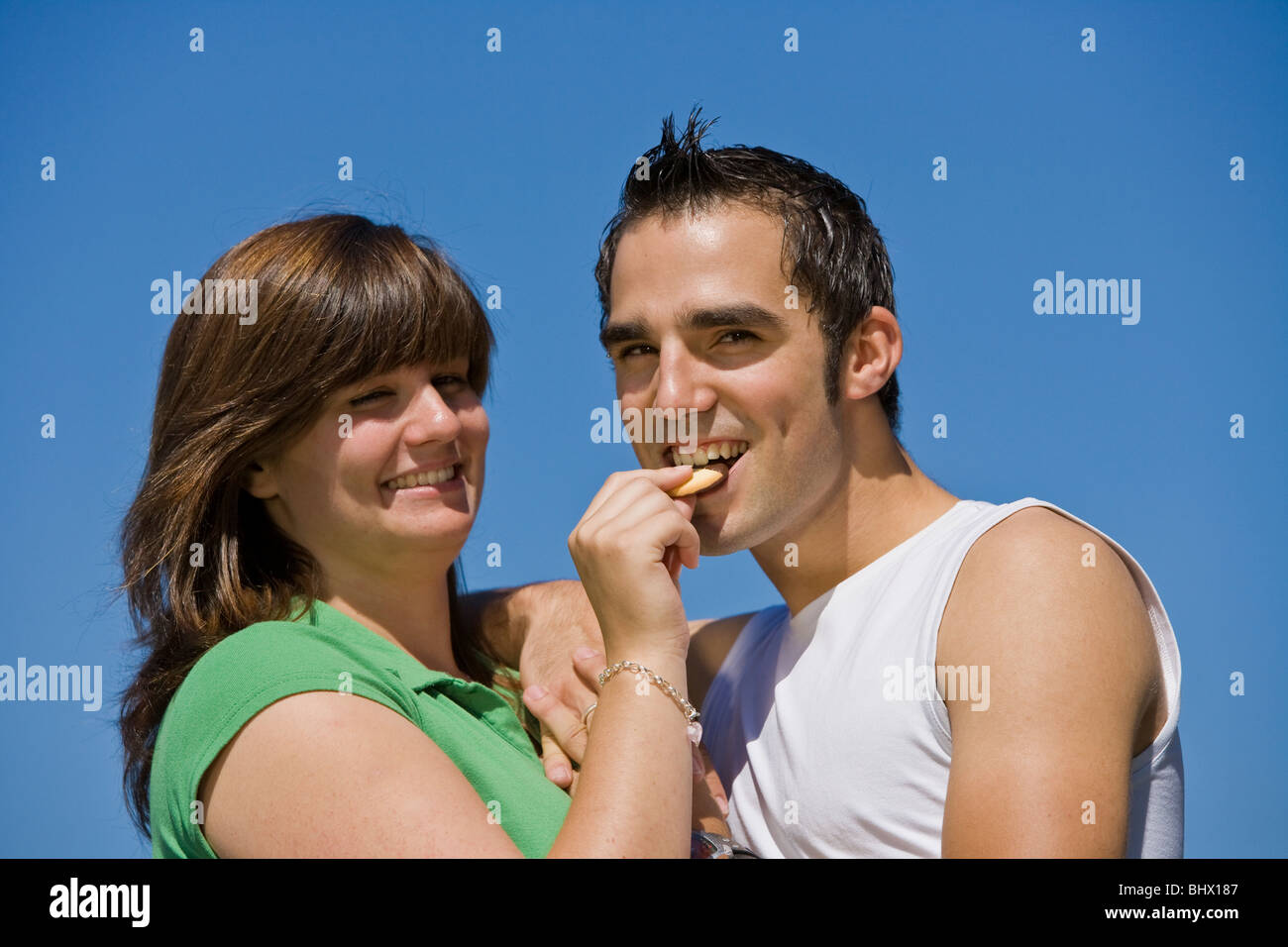 Couple sharing a cookie Stock Photo - Alamy