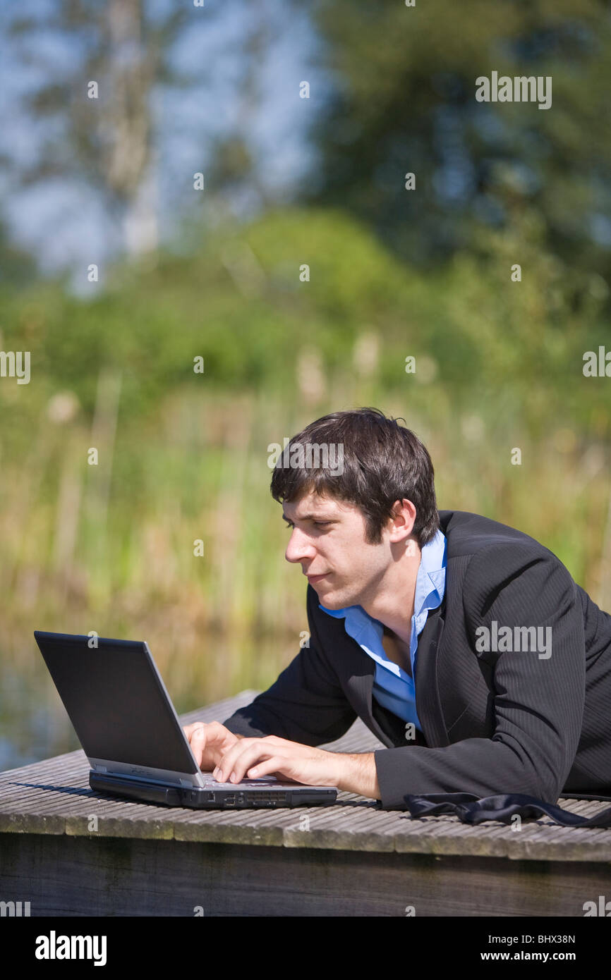 Young man working outside with a laptop Stock Photo - Alamy