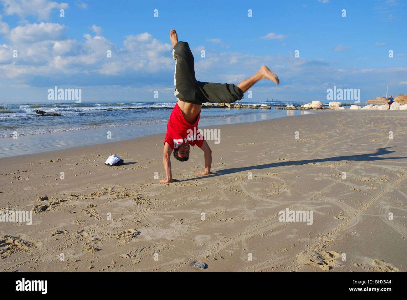 Israel, Tel Aviv, man somersaults on the beach somersault, summersault ...