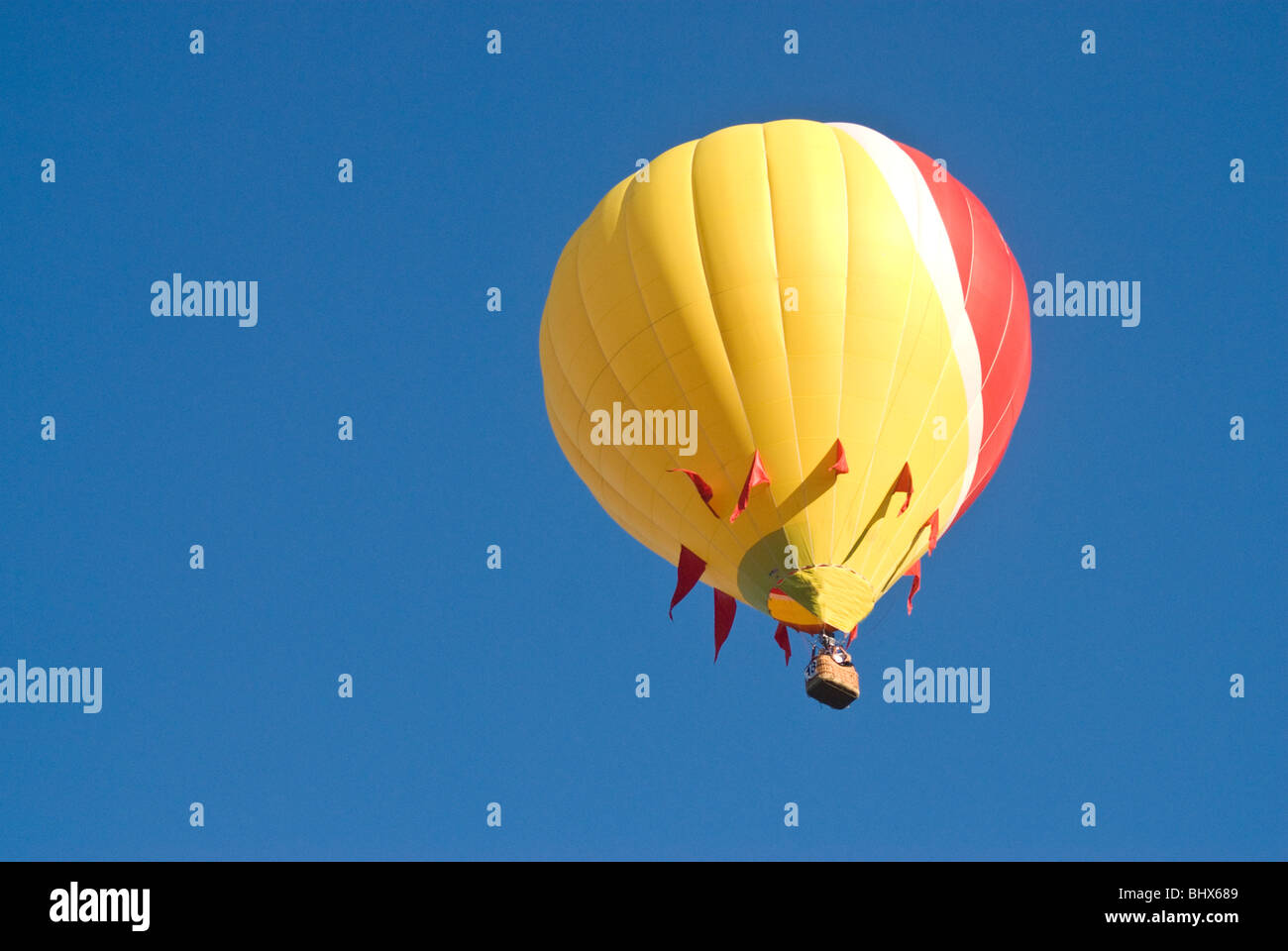 Big Hot air balloon flying up in a clear blue sky Stock Photo - Alamy