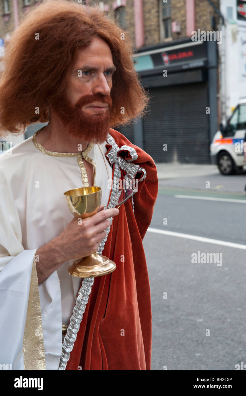 Red-haired man dressed as Jesus with gold cup waiting for procession in ...