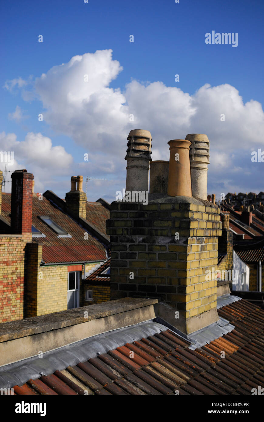 Chimneys and rooftops of Victorian terraced houses on a bright sunlit ...