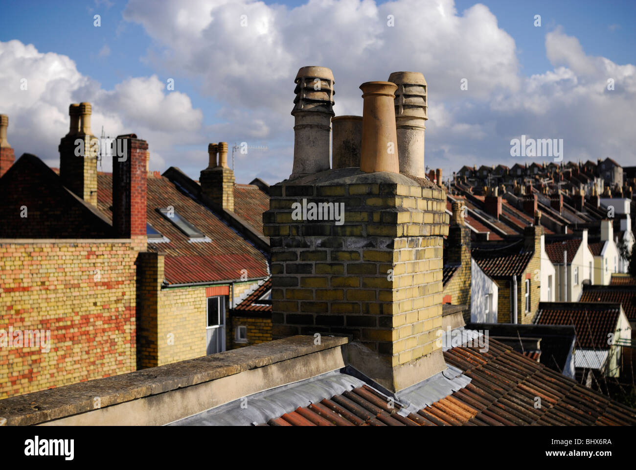 Chimneys and rooftops of Victorian terraced houses on a bright sunlit ...