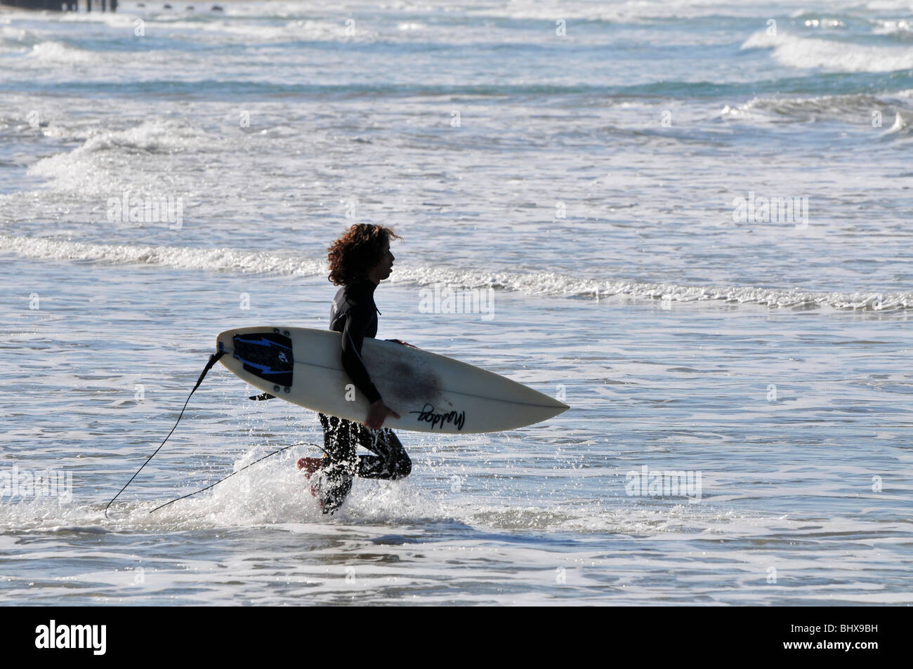 Israel, Haifa, Winter activity on the beach Surfer enters the sea Stock ...