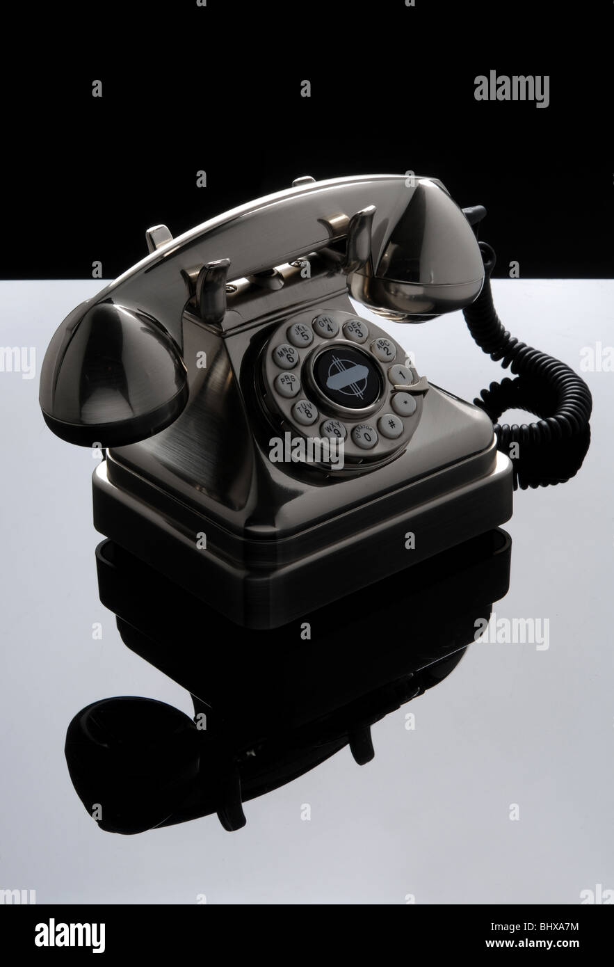 silver retro telephone on gray surface with black background Stock ...