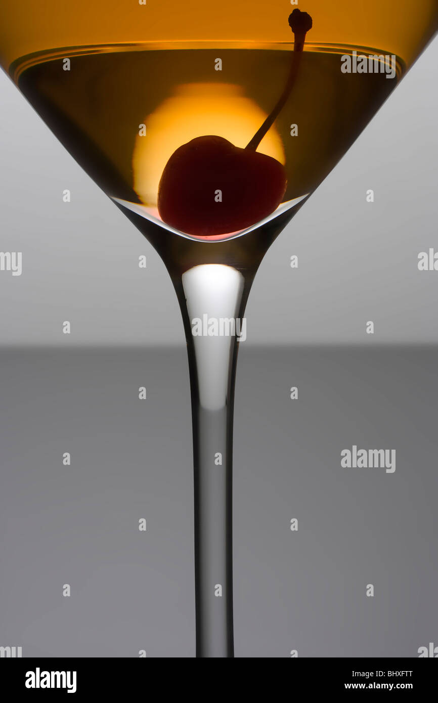 Manhattan cocktail with cherry garnish close up on gray background ...