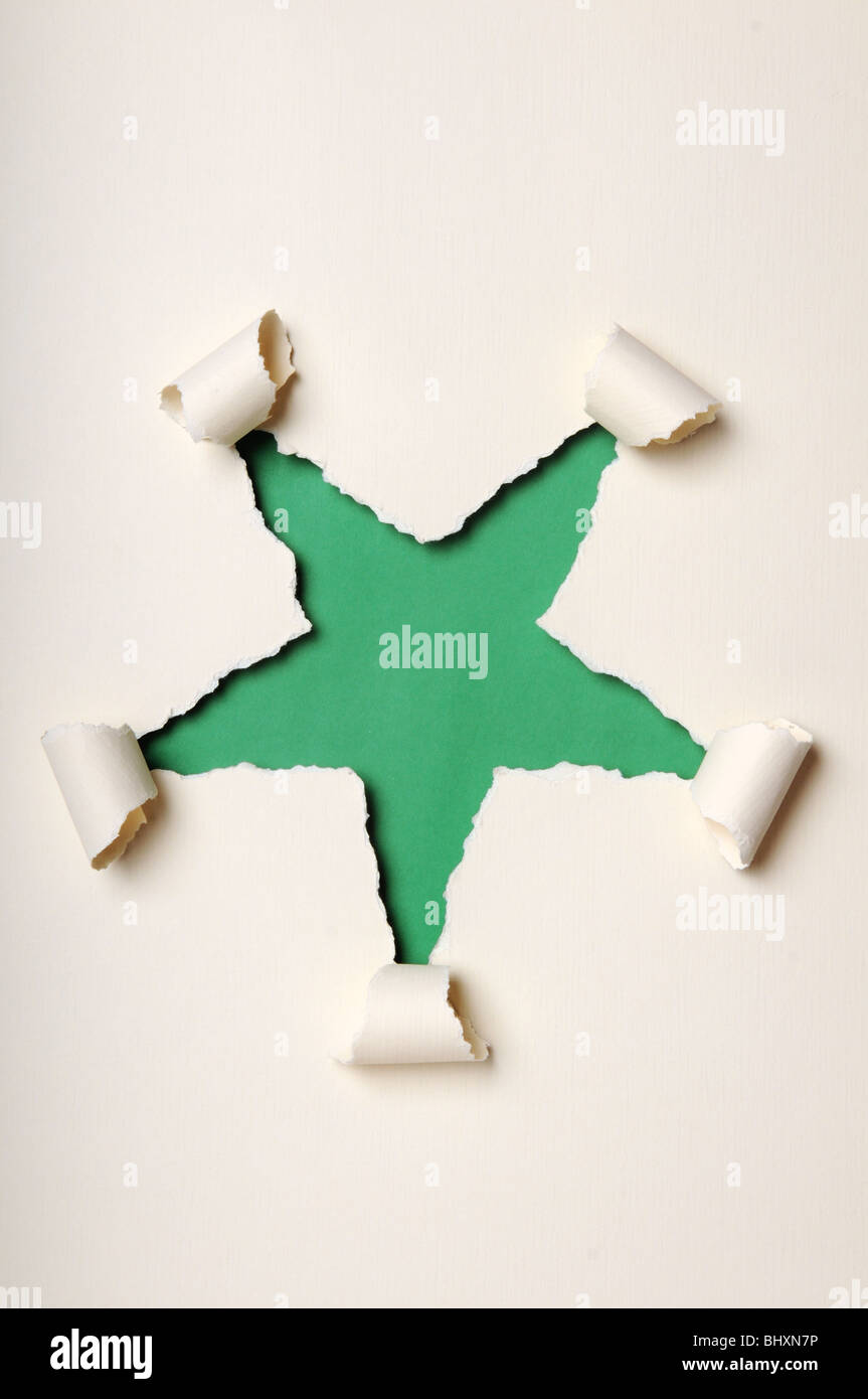 Old discolored paper ripped to form star over green background Stock ...