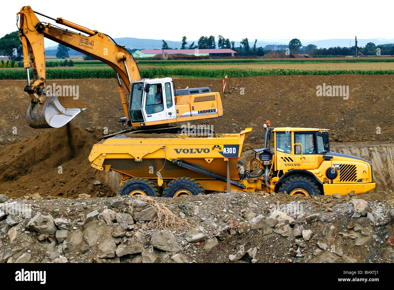 Crawler-type vehicle and truck on a building site Stock Photo - Alamy