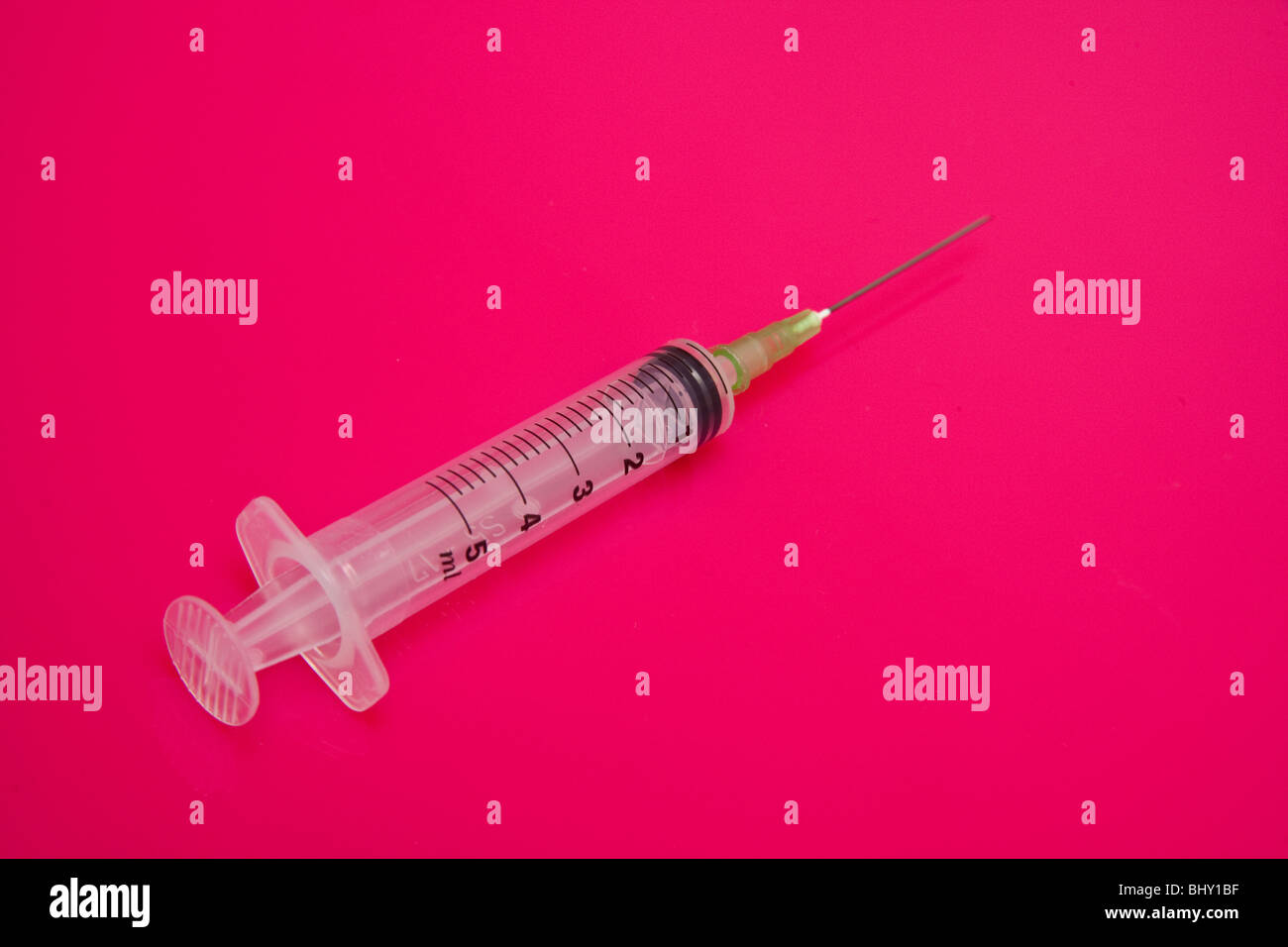 Needle and syringe on a bright pink studio background Stock Photo - Alamy