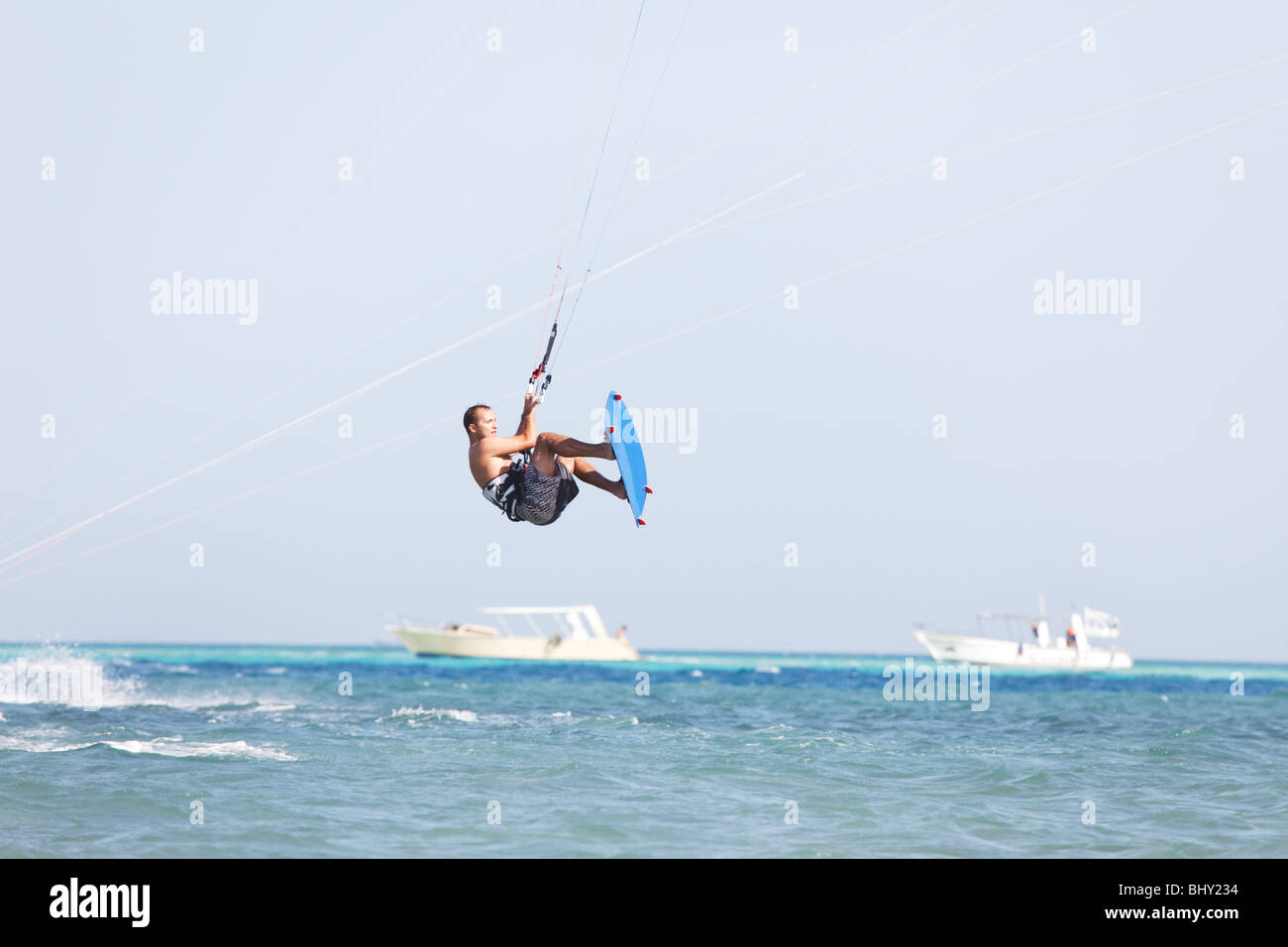 Kiteboarder enjoy surfing in blue water and jumps high in the air Stock ...