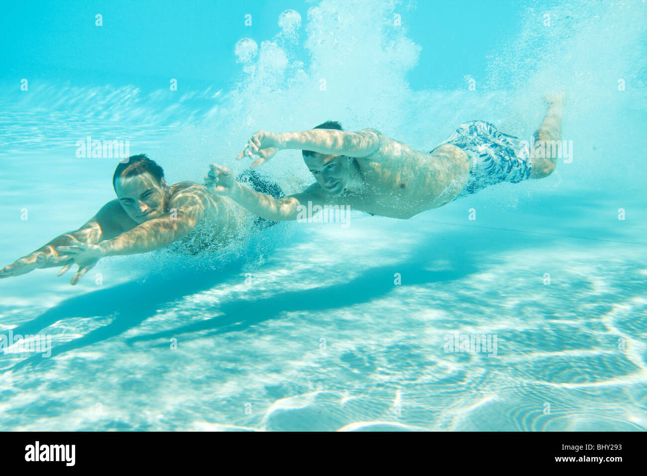 Two men swimming with open eyes underwater in pool Stock Photo - Alamy