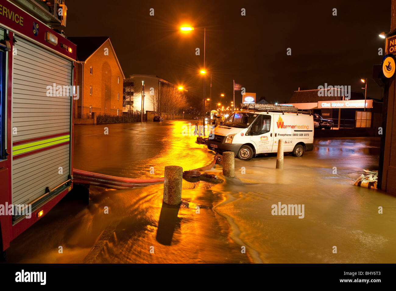 Fire engine pumping out flooded road and houses at night Stock Photo ...