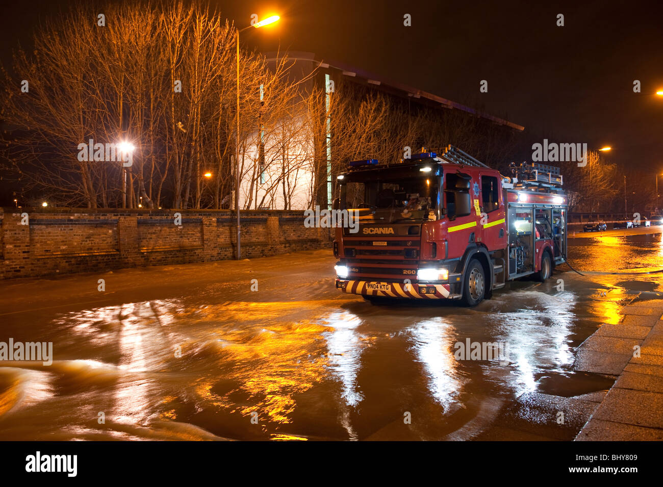 Fire engine pumping out flooded road and houses at night Stock Photo ...