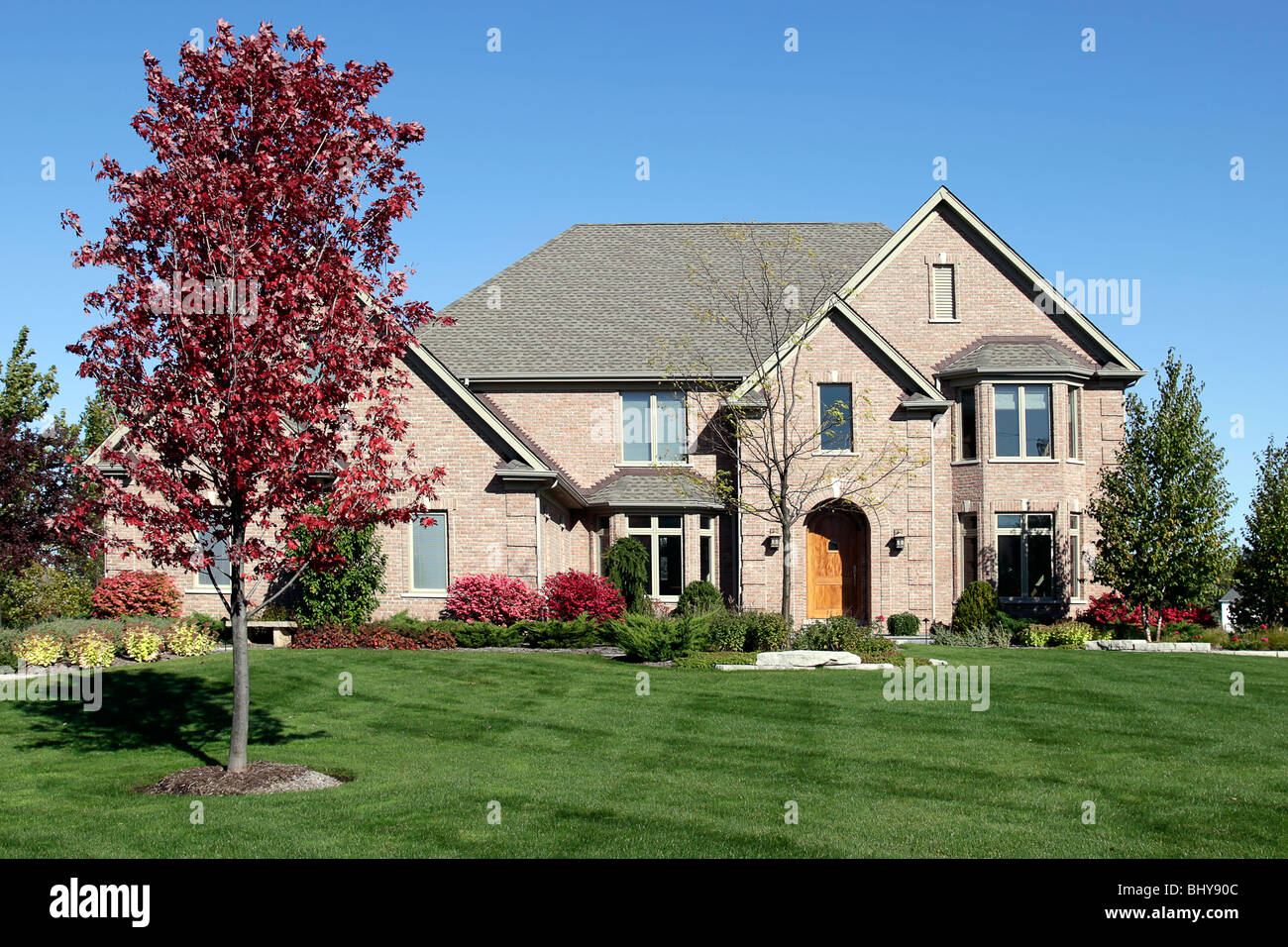 Large brick home in suburbs with arched entry Stock Photo - Alamy
