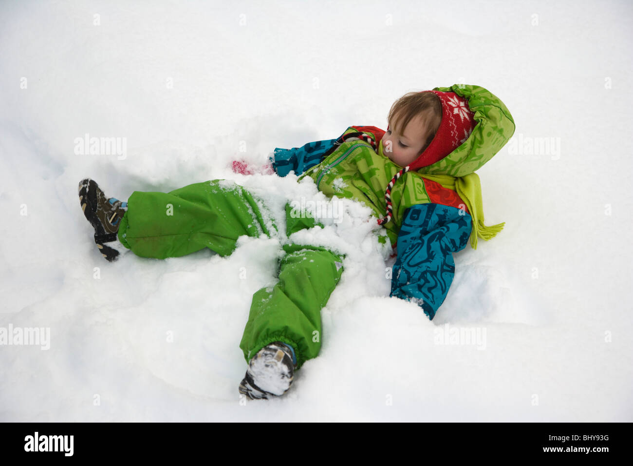 Toddler girl making snow angel Stock Photo - Alamy