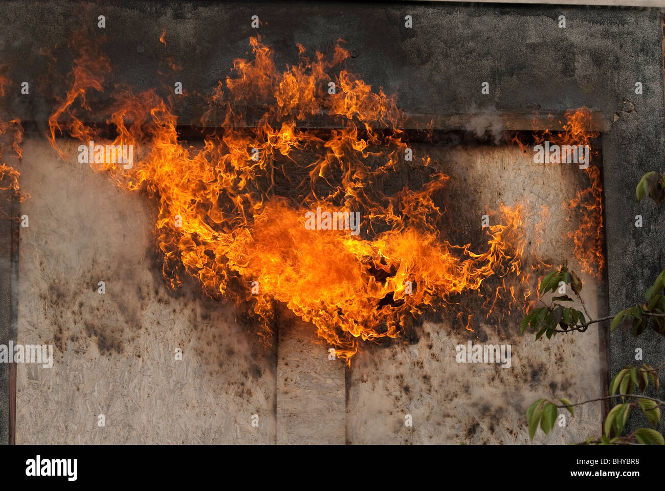 smoke and flames billowing from boarded up office on fire Stock Photo ...