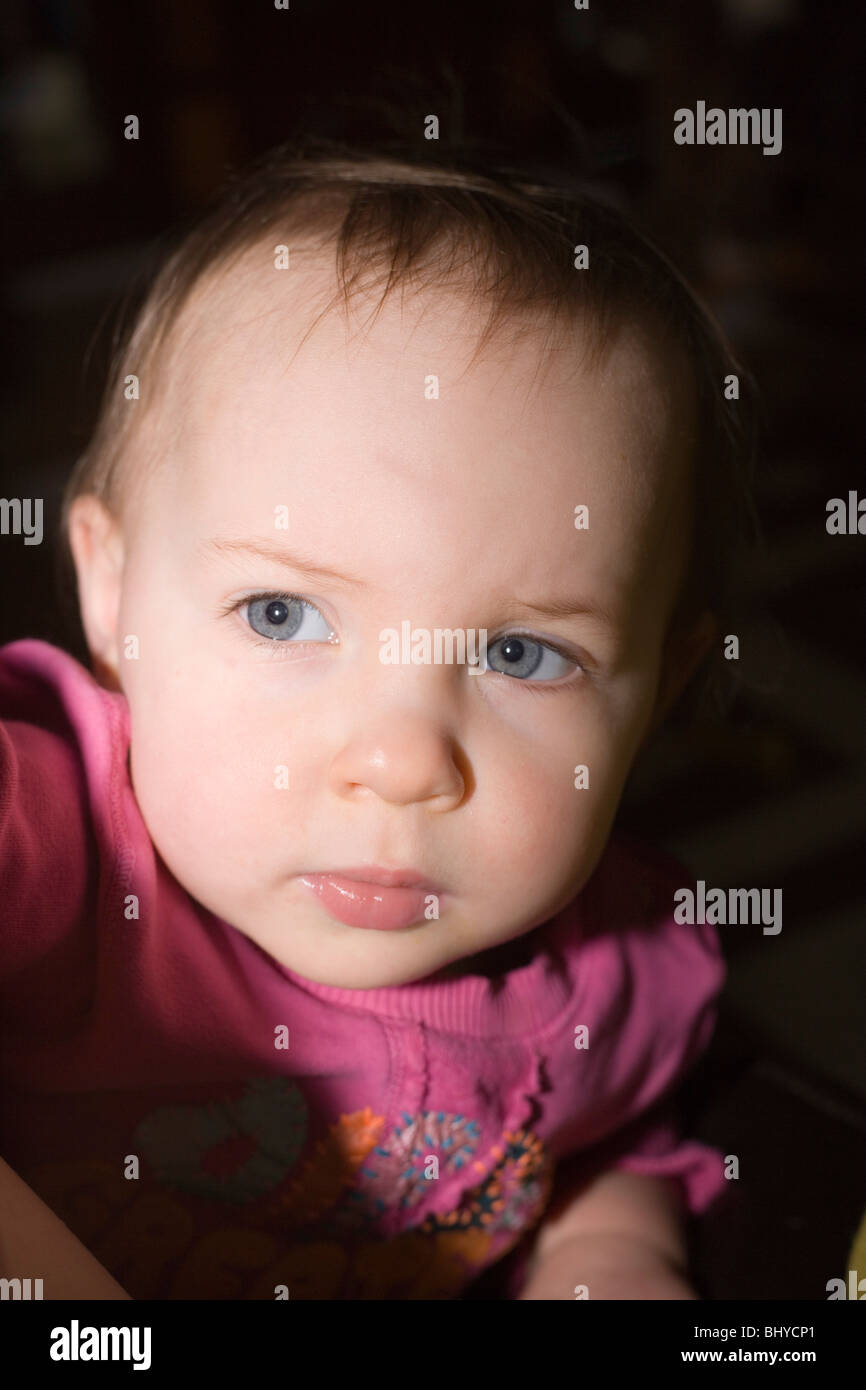 1 year old baby girl thinking about something serious. Lost in thoughts ...