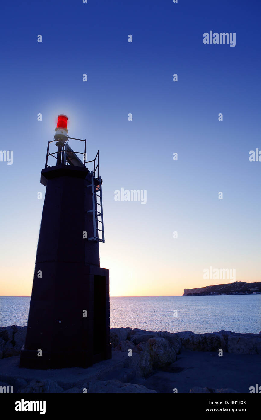 Blue sky and red lighthouse glowing on sunset sea Stock Photo - Alamy