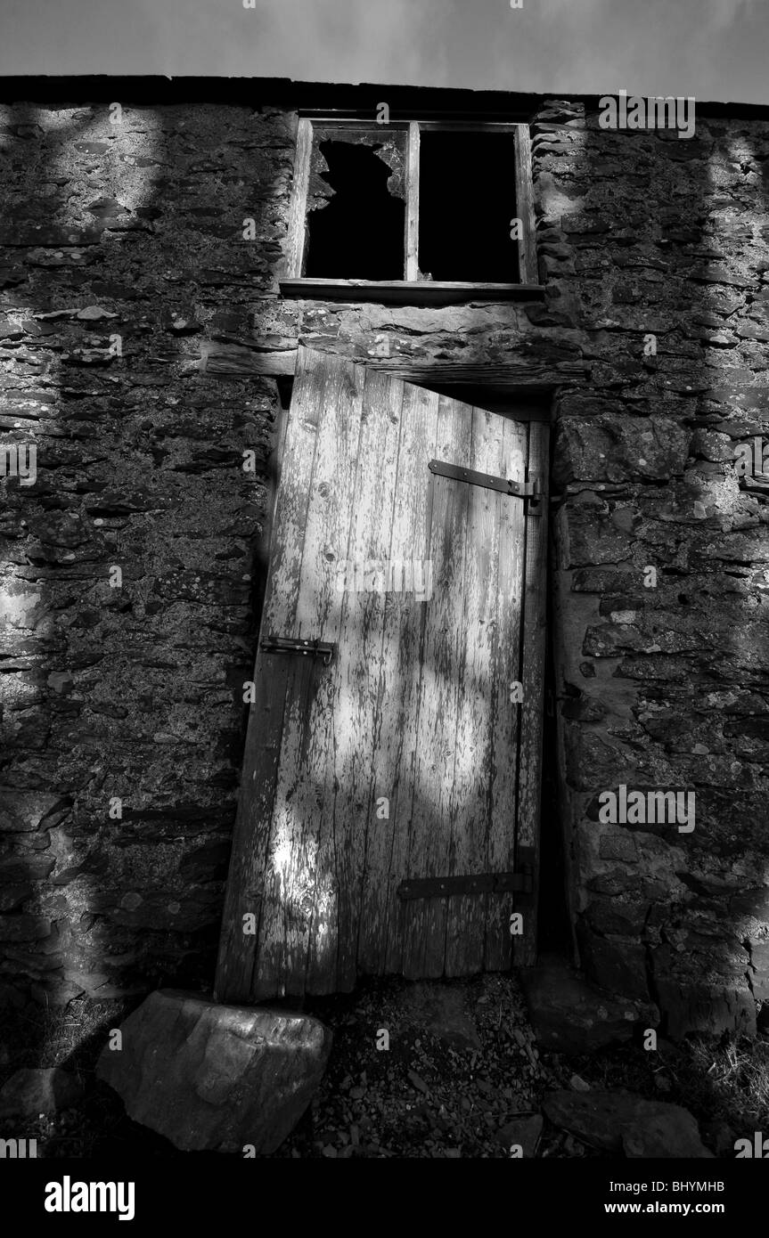 Welsh eerie barn with tree shadows and a broken window in Black and ...