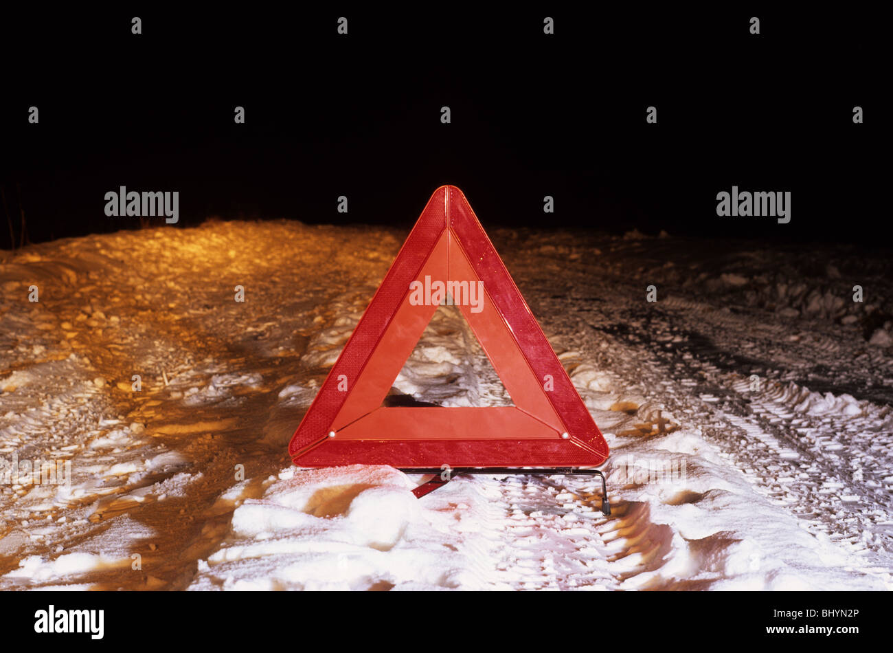 hazard warning triangle on country road in deep winter snow at night ...