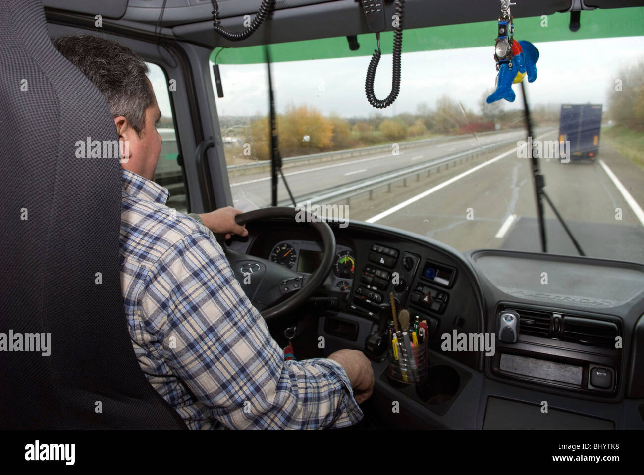 Driver behind the wheel of his lorry / truck Stock Photo - Alamy