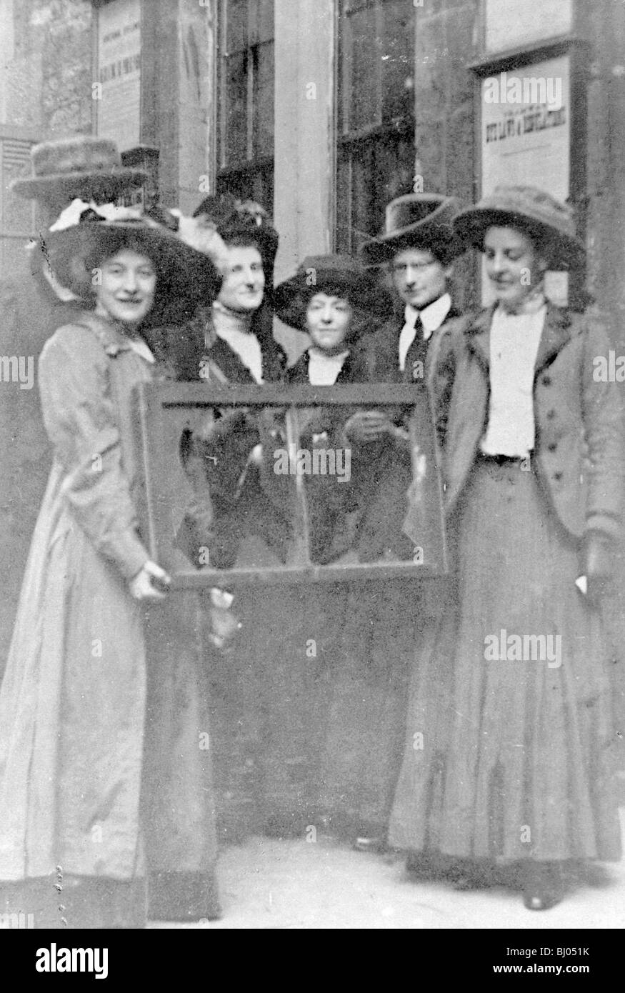 Five suffragettes holding a broken window in its frame, 1912. Artist ...