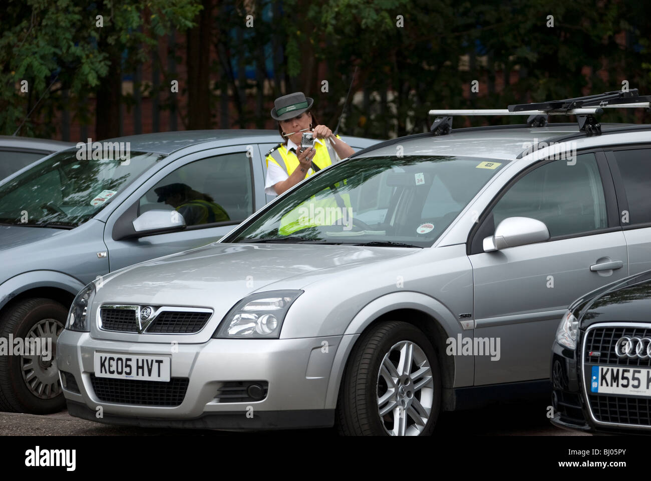 Traffic warden taking photograph of car Stock Photo - Alamy