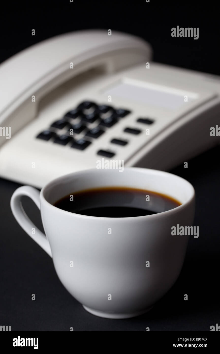 coffee cup and white telephone on black background Stock Photo - Alamy